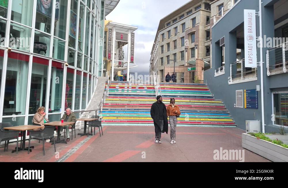 African couple walk from colourful stairs at Clock Tower Mall in V&A ...
