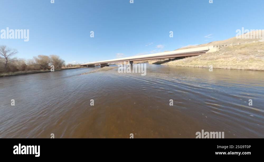 FPV racing drone flying low and fast over river water in Montana, USA ...