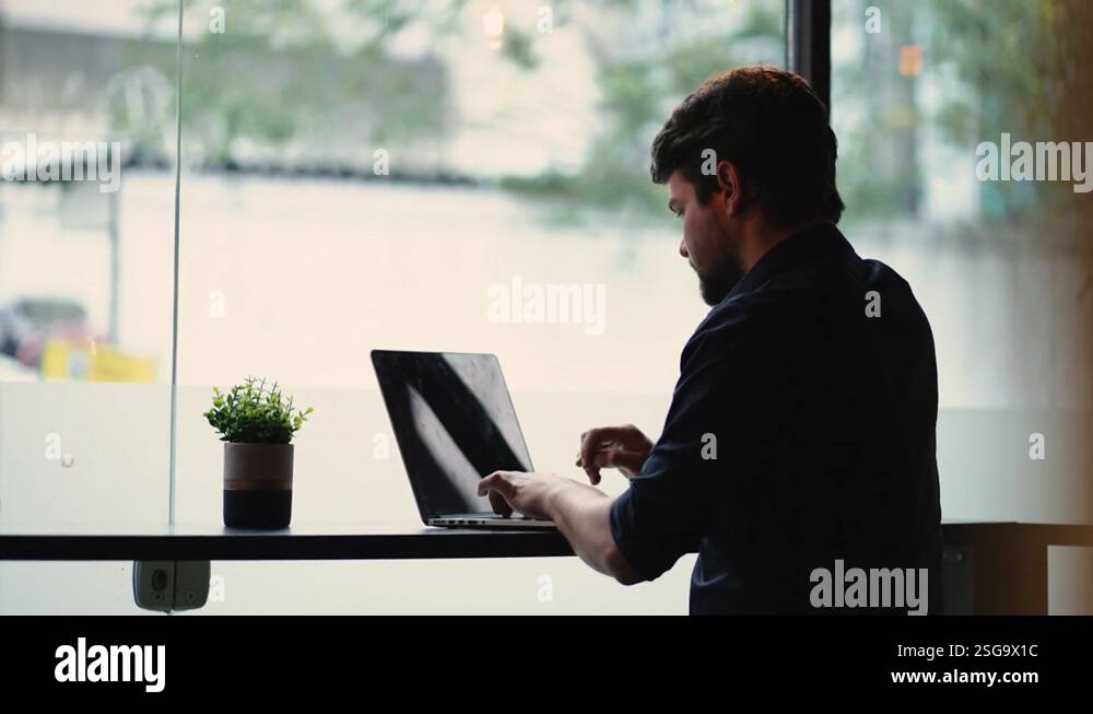 Person working at coffee shop typing on laptop computer. Young ...