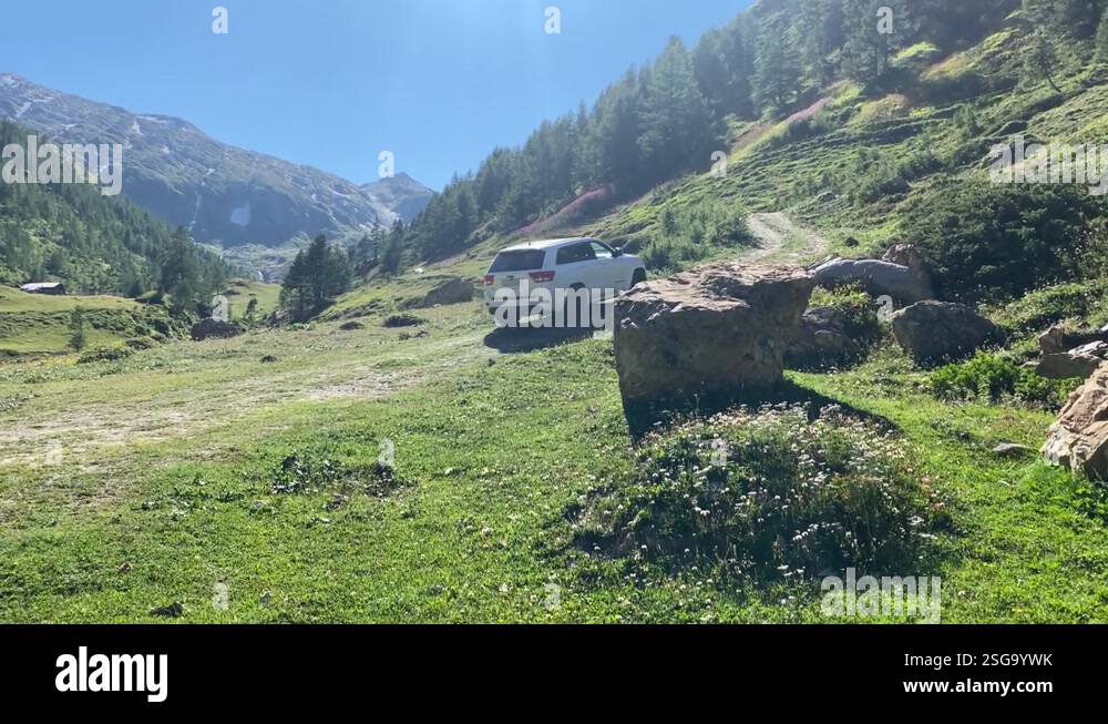 An SUV with all-wheel drive drives up a steep natural road in the Swiss ...