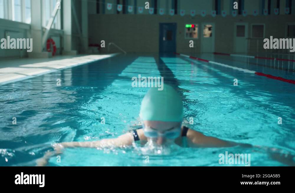 A beautiful young girl in turquoise swimsuit come up to the surface ...