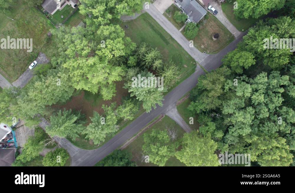 Drone footage of a quiet suburb with clear roads and many houses that ...