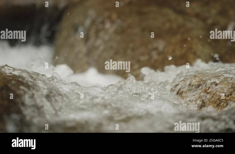 focus rack of river running through rocks with water flowing 120fps (4k ...