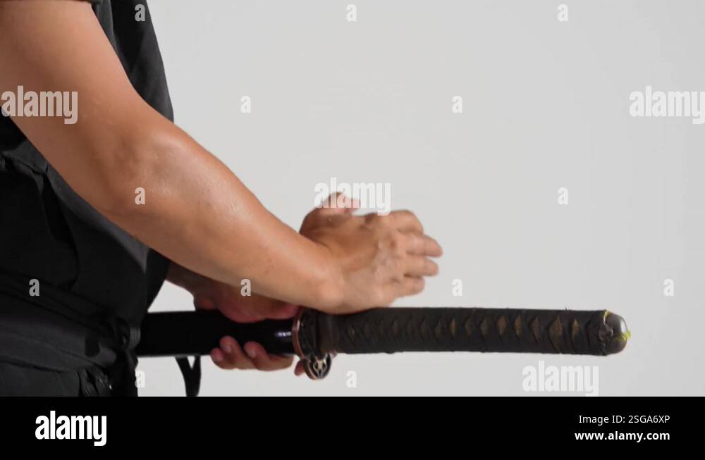 A Japanese man pulls out a katana from a samurai sword sheath in a ...