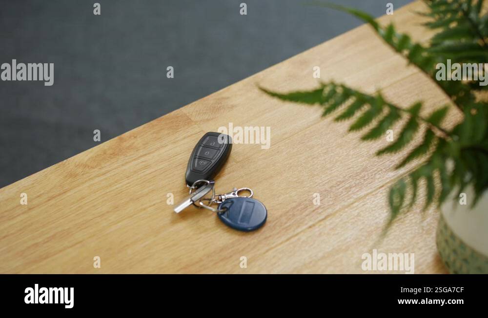 Picking up keys on a table. A man grabs his car keys as he leaves the ...