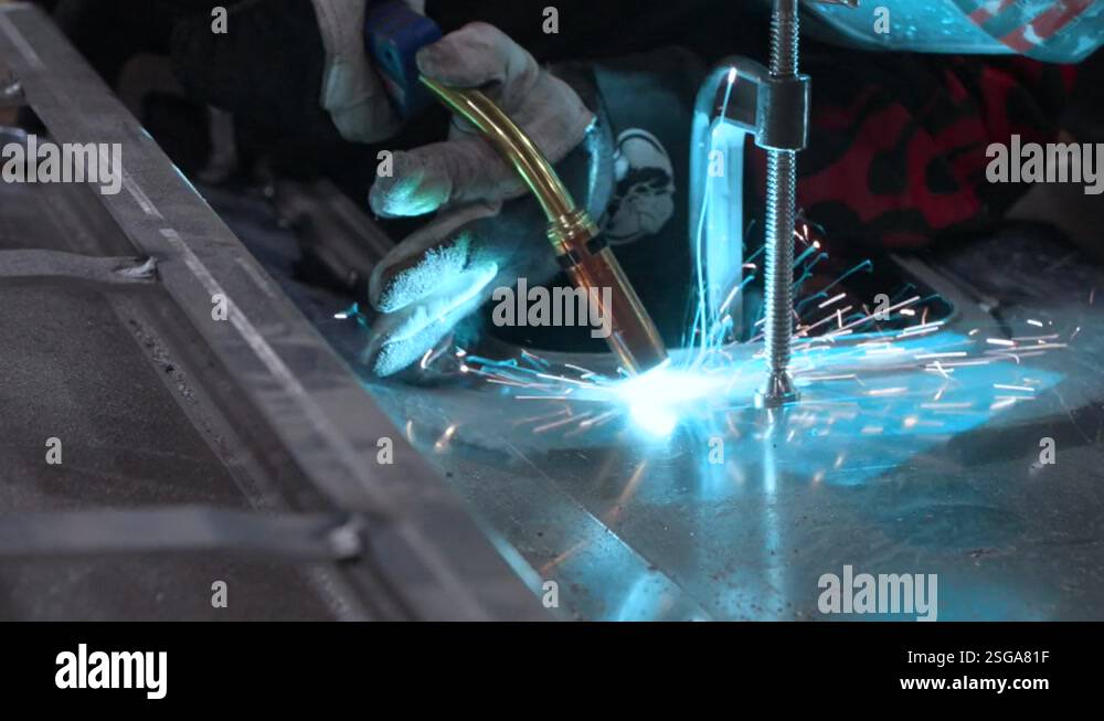 Close-up of worker's hands welding metal - weld on an aluminum part to ...