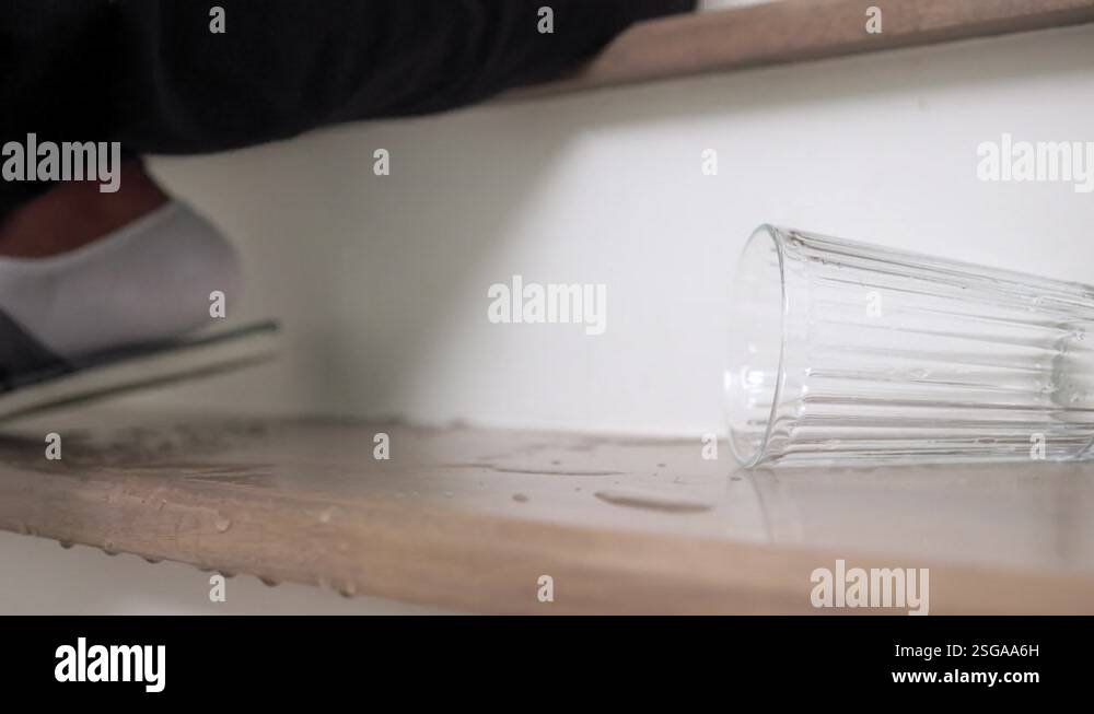 Close-up a glass of water placed on the stairs of the house is spilled ...