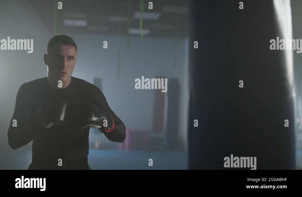 Fighter trains his punches in the boxing gym, a man boxer beats a ...