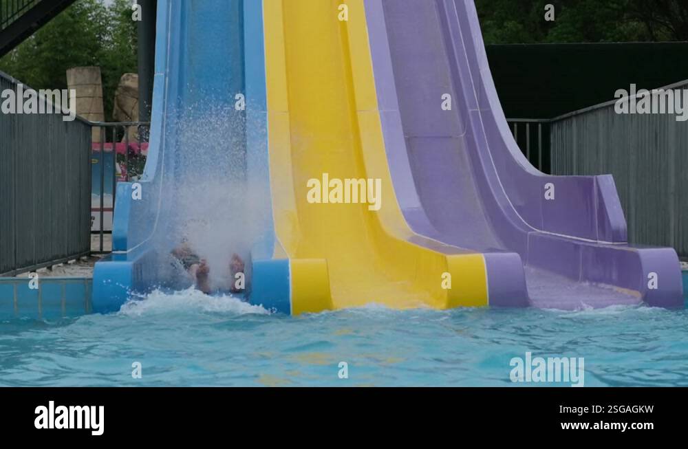 young man sliding on body slide with splash at water park Stock Video ...