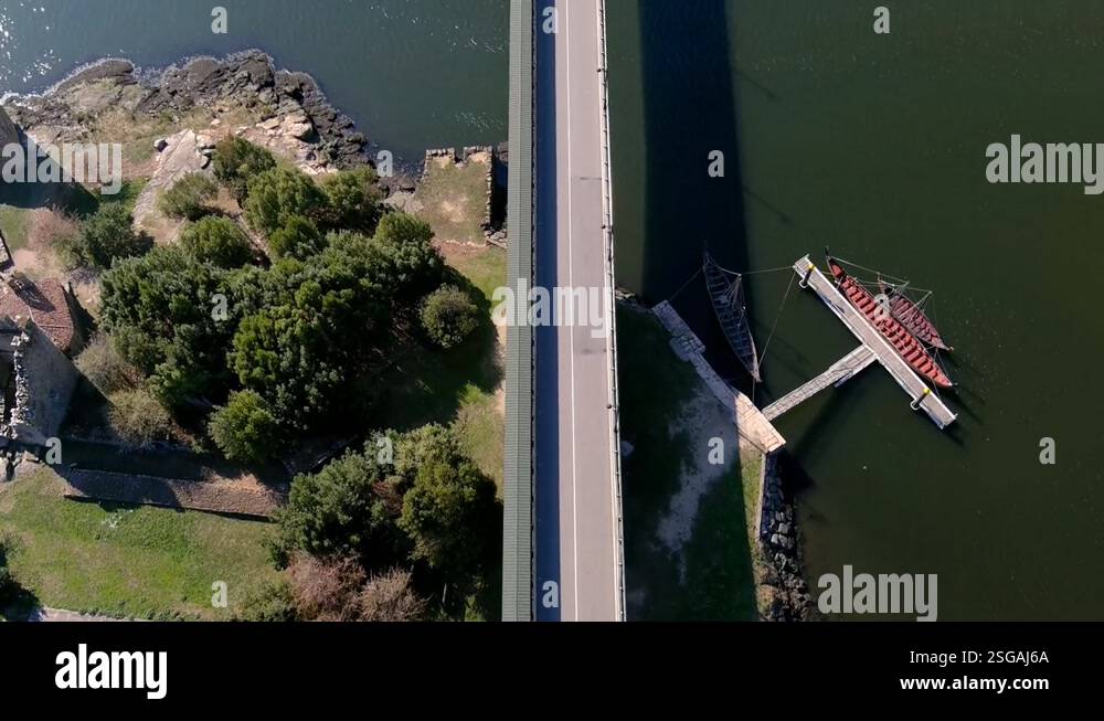 cars driving over the bridge over the Ulla River with Viking boats on ...
