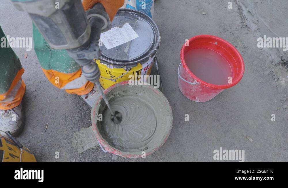 Mixing mortar in a bucket. The mortar is kneaded in a bucket with a ...