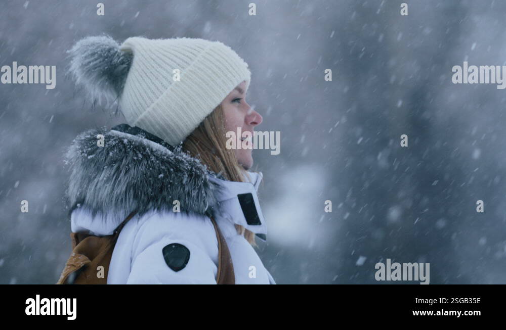 Female model is under snowfall in winter forest landscape on blurred ...