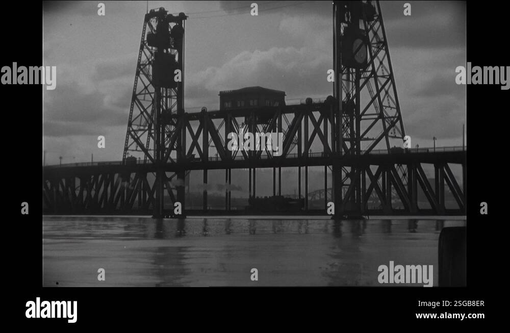 1930s: Train crossing bridge over river. Drawbridge over water. People ...