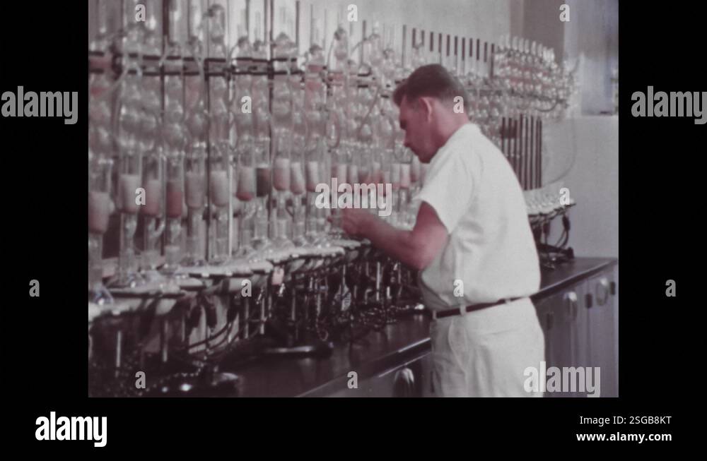 1960s: Row of chemistry equipment in pharmaceutical lab. Man works with ...