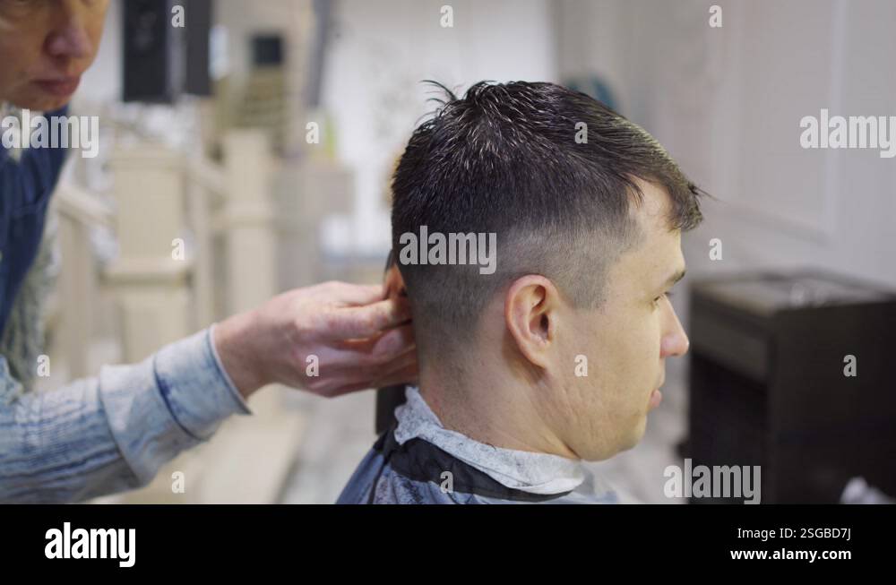 hairdresser makes a haircut of nape for a man with a hair clipper in ...