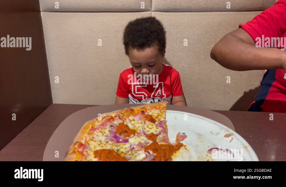 Exotic and adorable two year old kid eating pizza for the first time ...