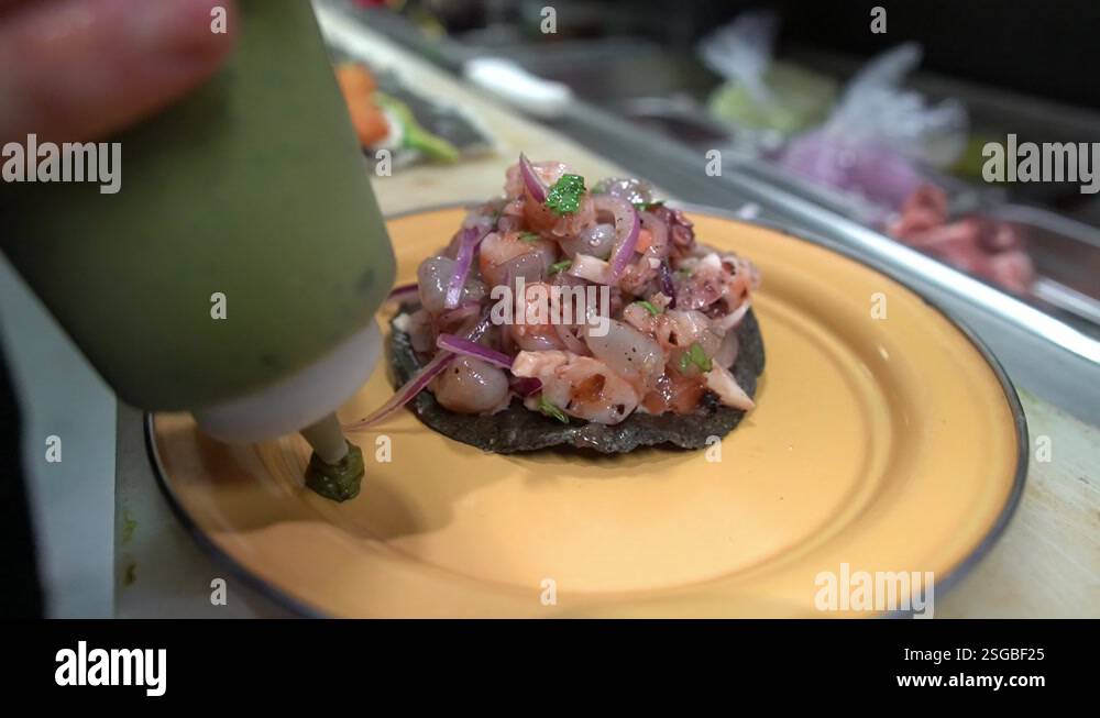 dressing with cilantro dressing a ceviche tostada on the plate ready to ...