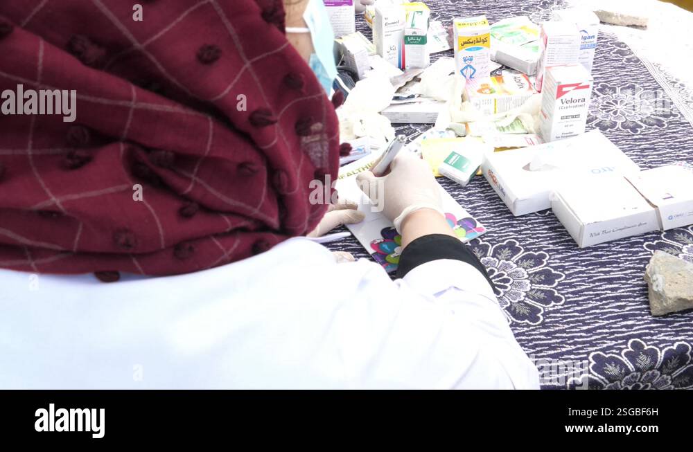 Over The Shoulder View Of Female Doctor Writing Prescription At Flood ...