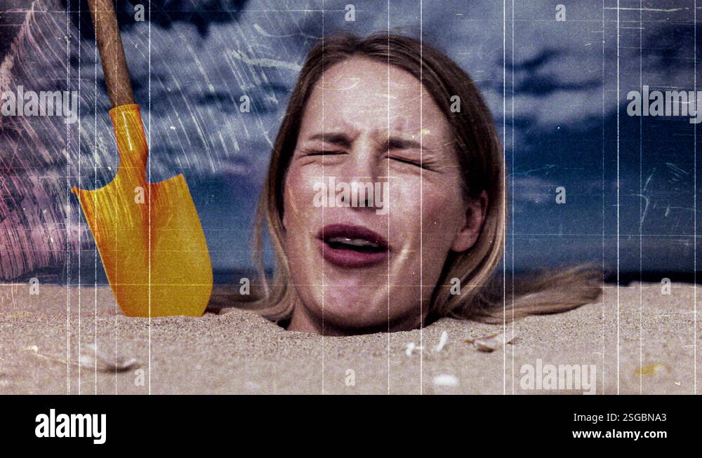 Woman buried in sand on beach with spade Stock Video Footage - Alamy