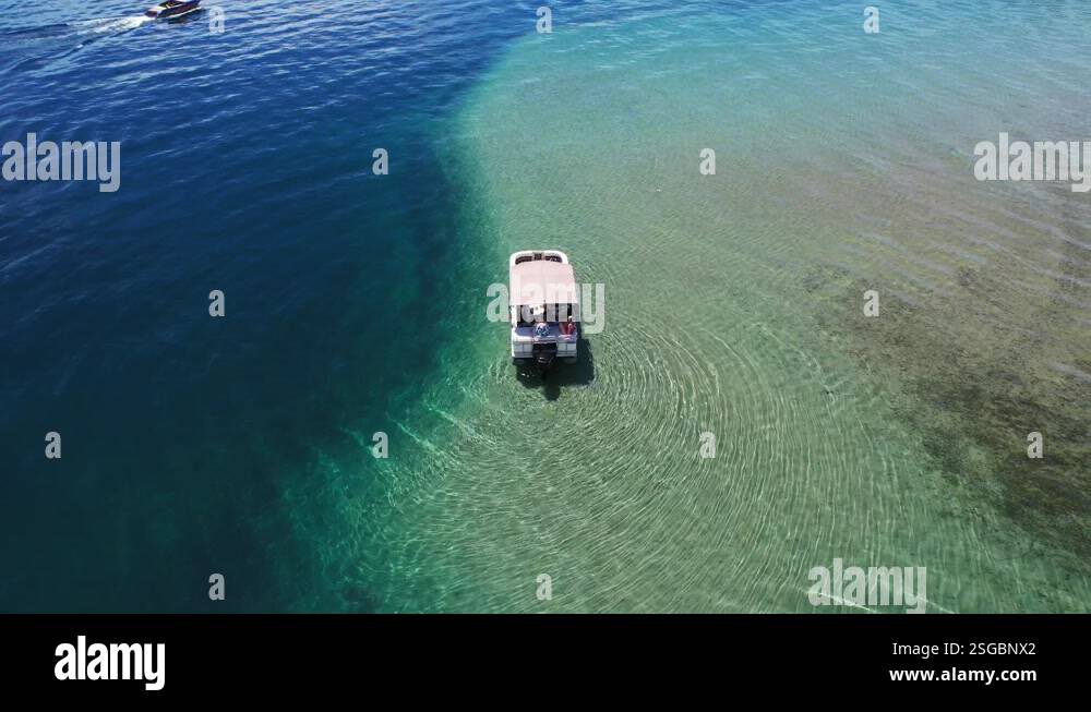 A pontoon boat is anchored on the edge of the drop-off at Detroit Point ...