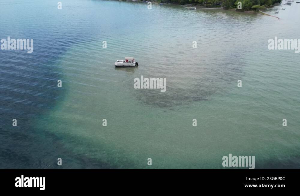 A pontoon boat is anchored on the edge of the drop-off at Detroit Point ...