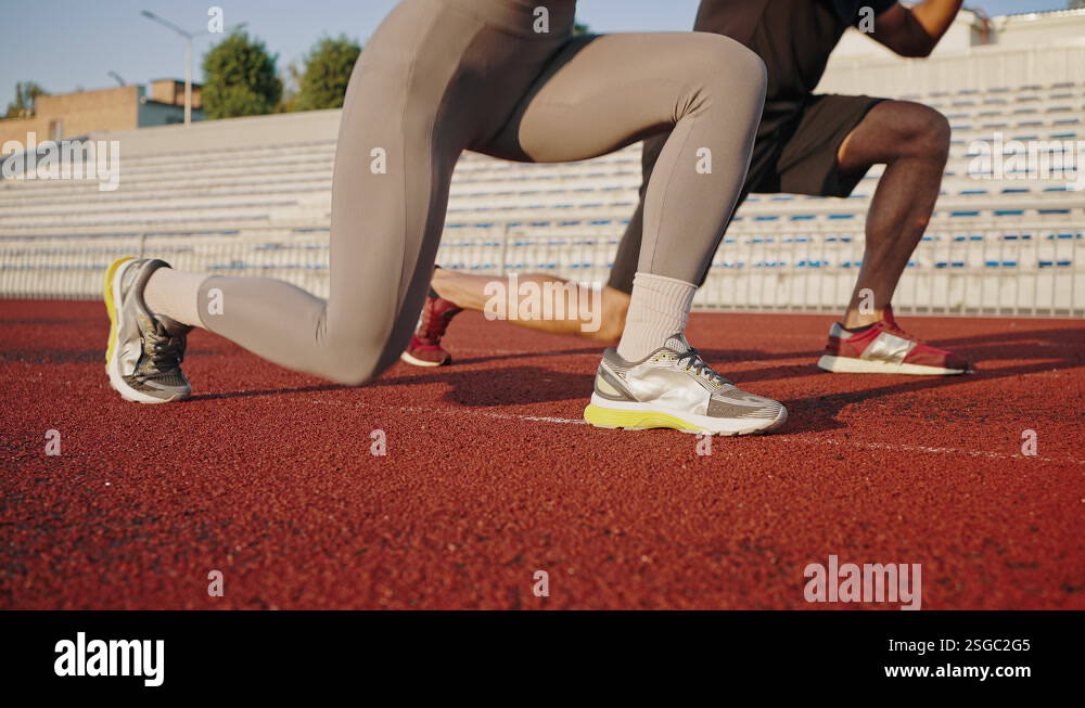 Male and female legs squat and lunge back on running track Stock Video ...