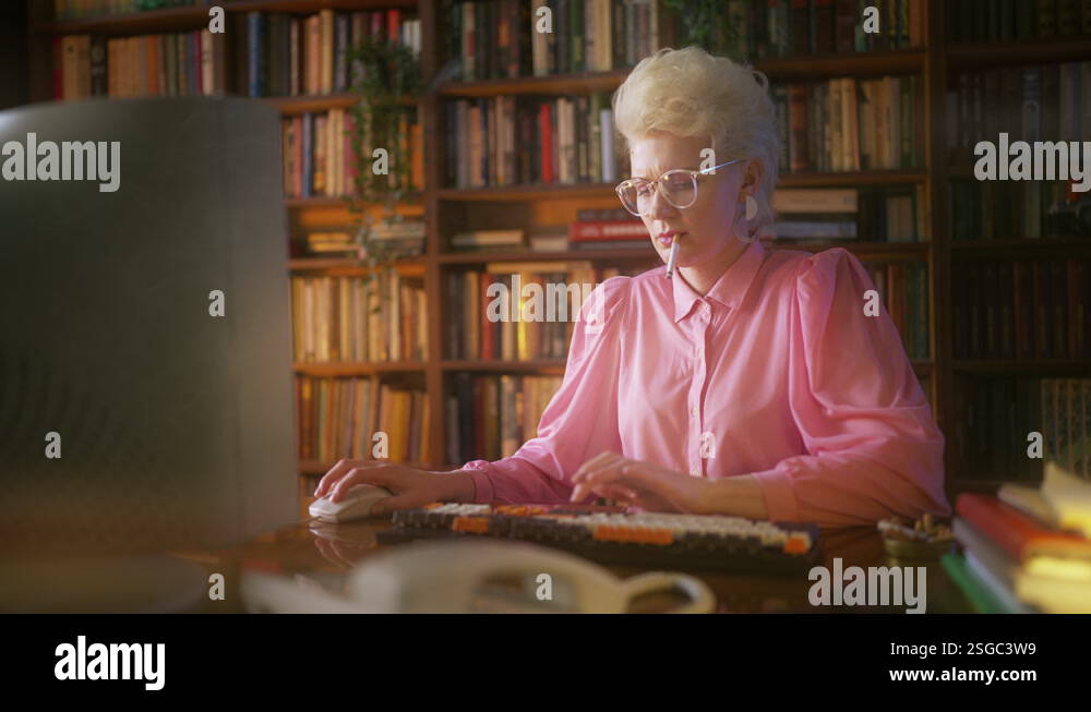 Woman smoking cigarette and working on computer, female writer from 80s ...