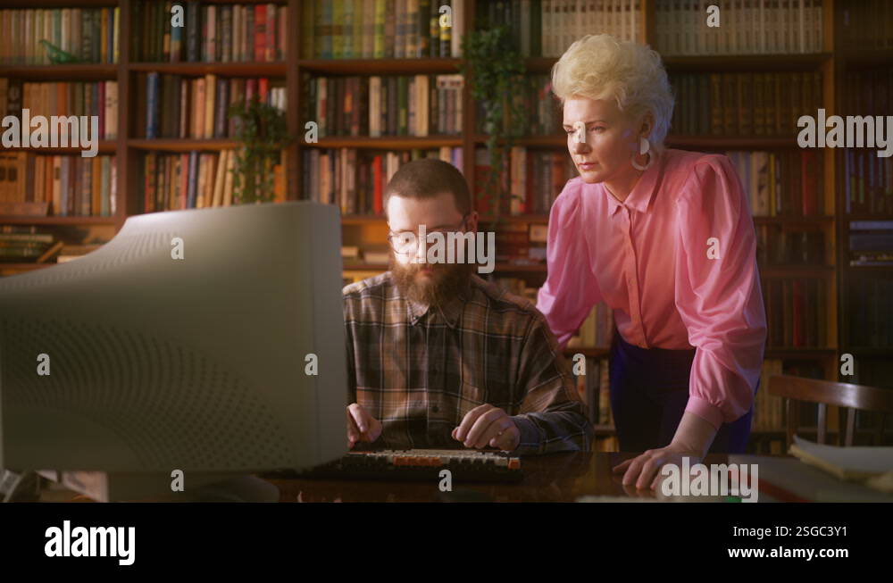 IT guy and female boss working on computer in vintage office, teamwork ...