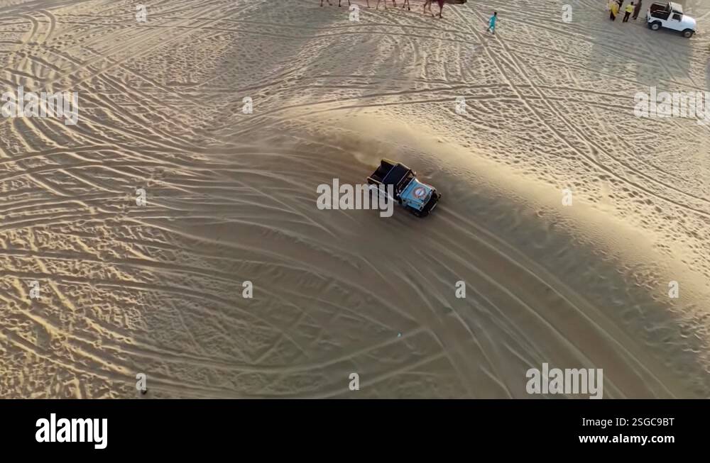Drone tracking of a car driving in the Sahara desert of Rajasthan Stock ...
