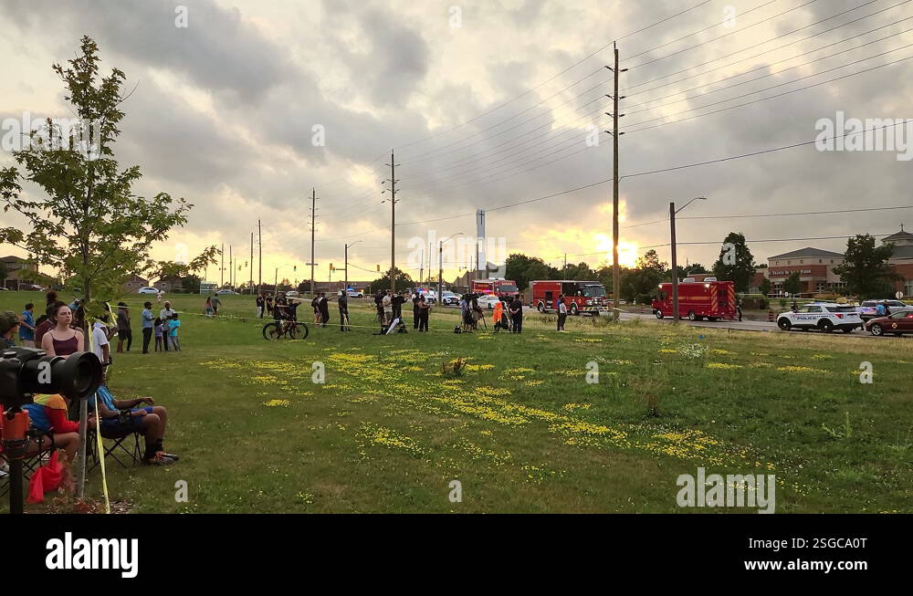 People watching from grass field a crime scene with Firefighters ...