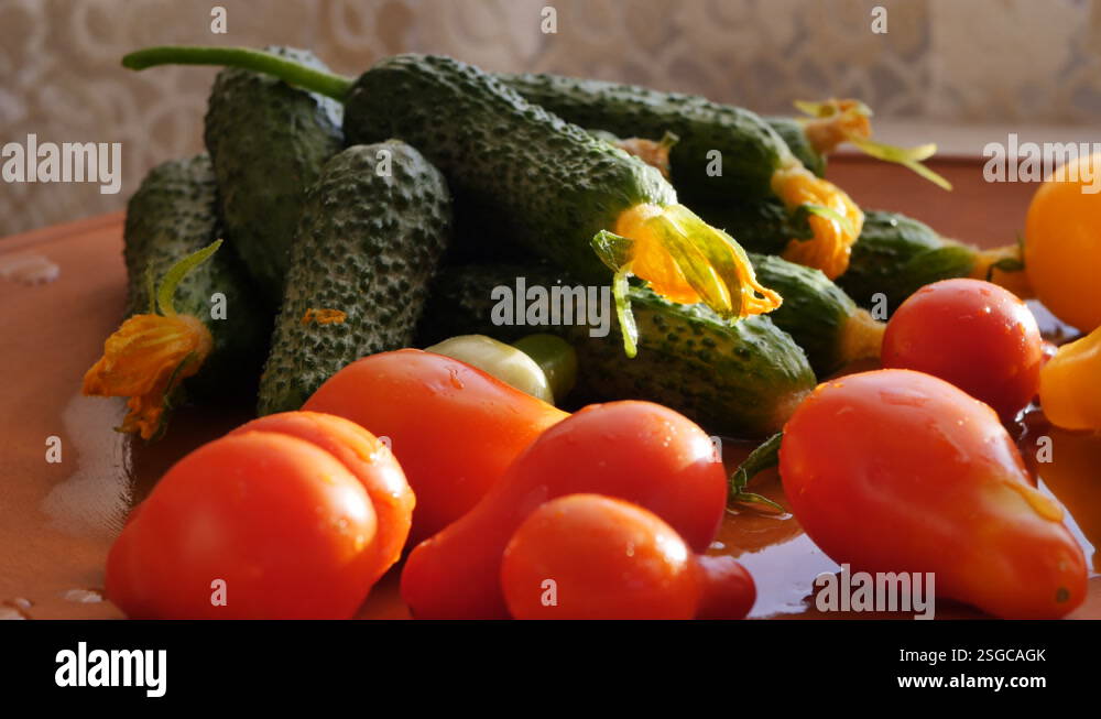 The hands of a person dump fresh red and yellow tomatoes into a plate ...
