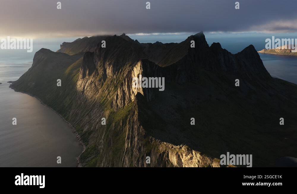 Dramatic cliffs dropping into the sea in the Arctic Norwegian sea Stock ...