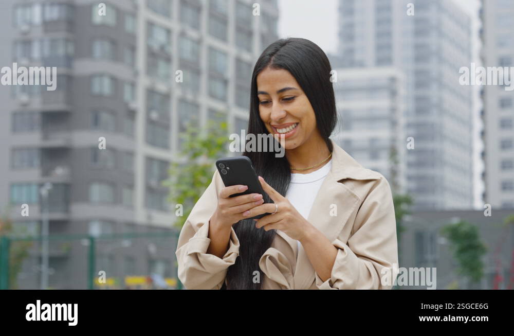Young amiable black woman texting message on terrace of shopping mall ...
