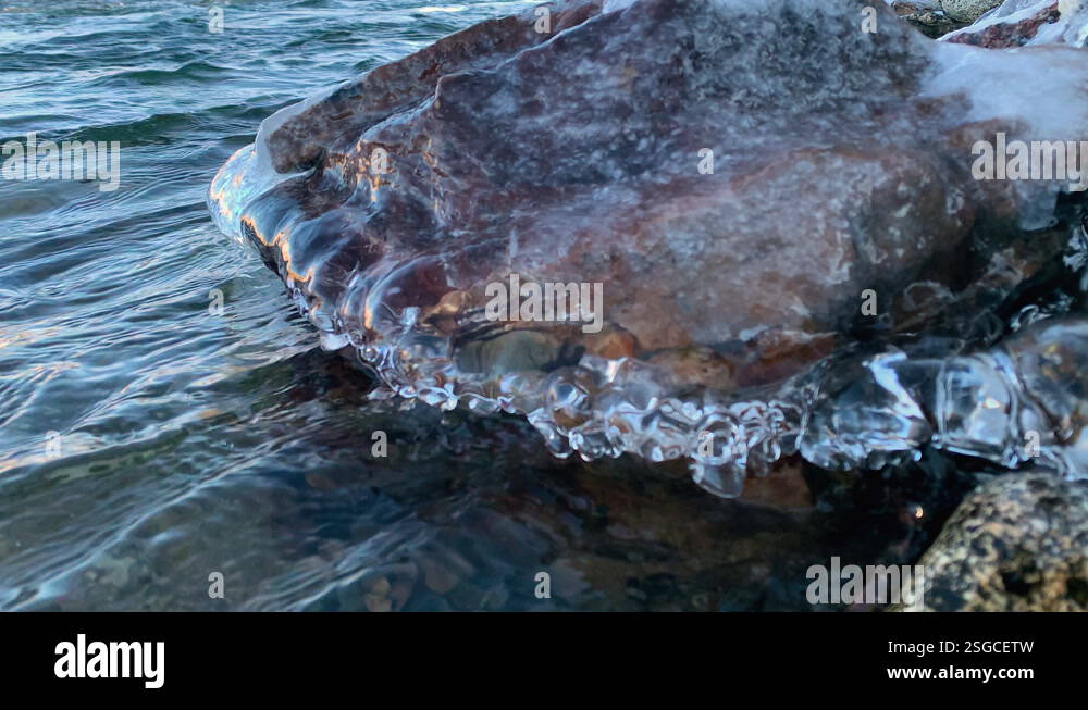 Close up of ice covered rock on bank of Spokane River during winter ...