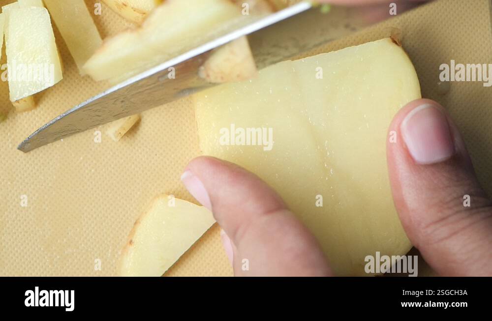 slow motion of cutting slice of raw potato on chopping board Stock ...