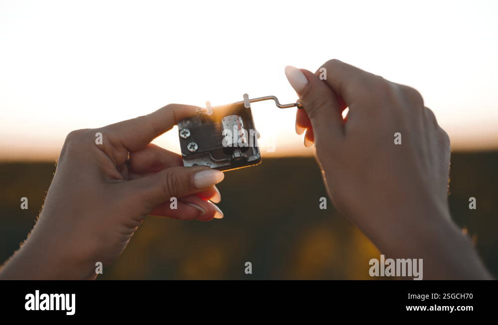 Female hands rotating gears of old music box mechanism. Lady turning ...