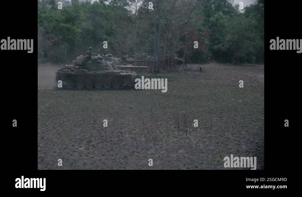 Vietnam 1960s: Soldiers in tanks move across an open field. Tanks drive ...