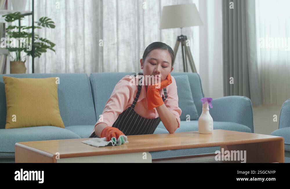 Sad Asian Female Housekeeper With An Apron Cleaning The Table By The ...