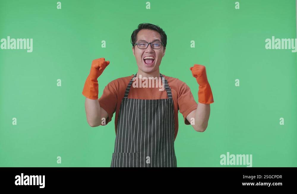 Happy Asian Male Housekeeper With An Apron Celebrating While Standing ...