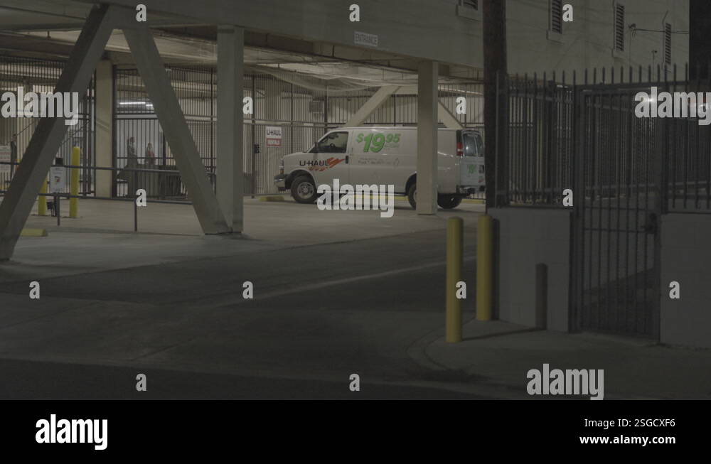 A static shot of a car being parked in the parking area at night. A ...