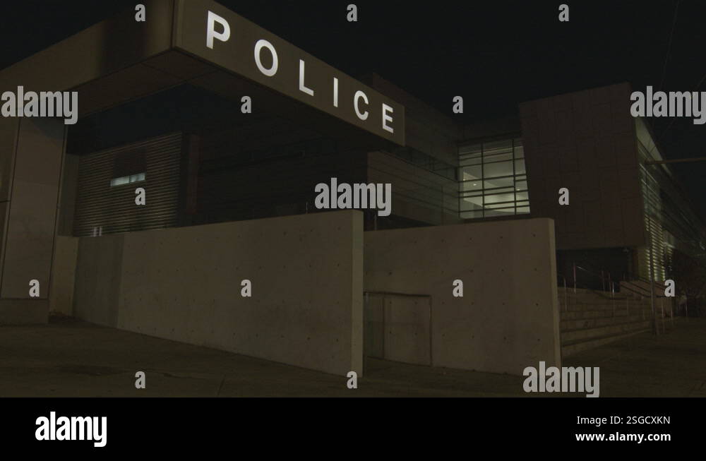 Police station logo and sign lit up at night. Law enforcement building ...