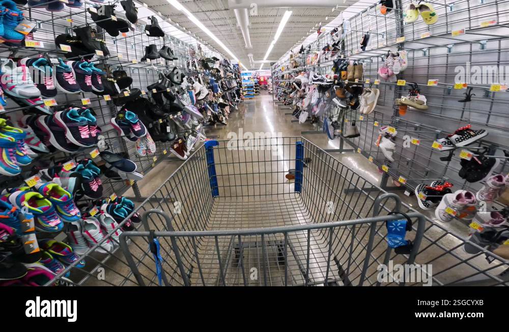 POV while pushing a cart through Walmart in shoe section; many pegs and ...