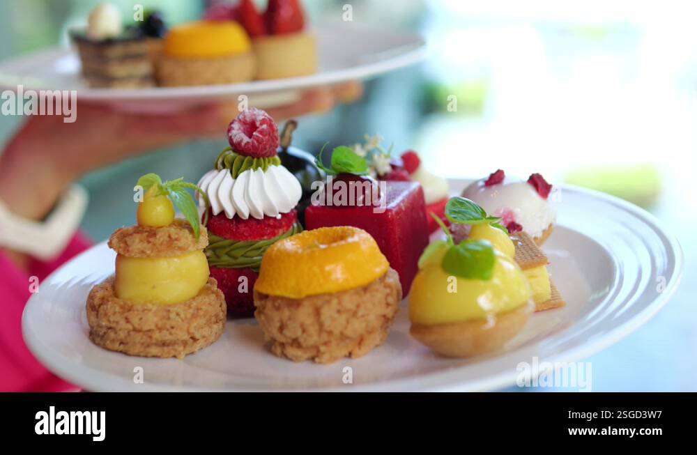 Human hands hold two plates of dessert cakes for two persons. All cakes ...