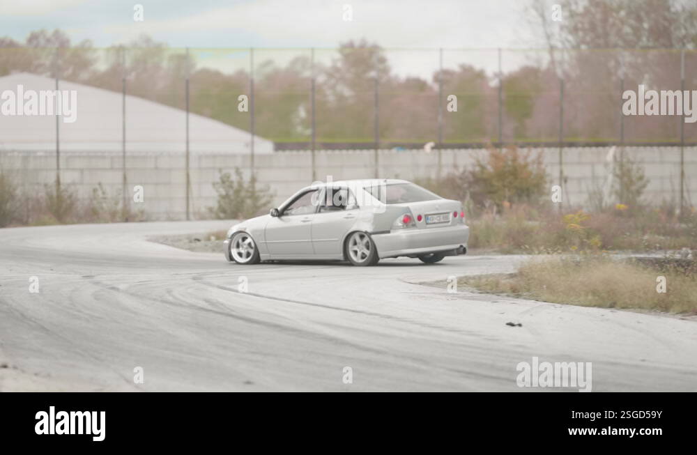 Silver BMW sliding sideways on racetrack long shot in slow motion 4K ...