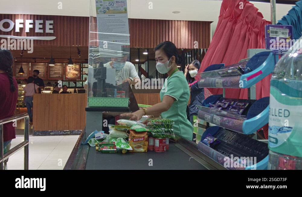 Cashier scanning goods at the register inside Metro Supermarket in ...