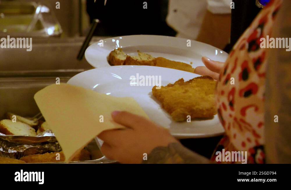 close up static shot of a buffet while guests are putting vegan food on ...