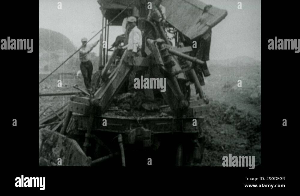 1940s: Man drives train down tracks with bulldozer attachments on sides ...