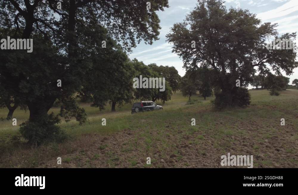 A tripod shot following a 4wd vehicle climbing a light slope between ...