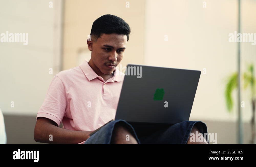 A hispanic young man turning computer ON. Person opening laptop sitting ...