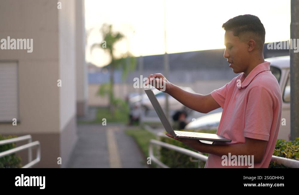 A hispanic young man turning computer ON. Person opening laptop sitting ...